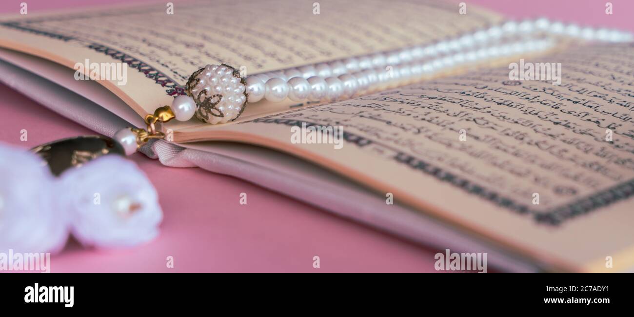 Holy Quran with rosary beads with pink background Stock Photo - Alamy