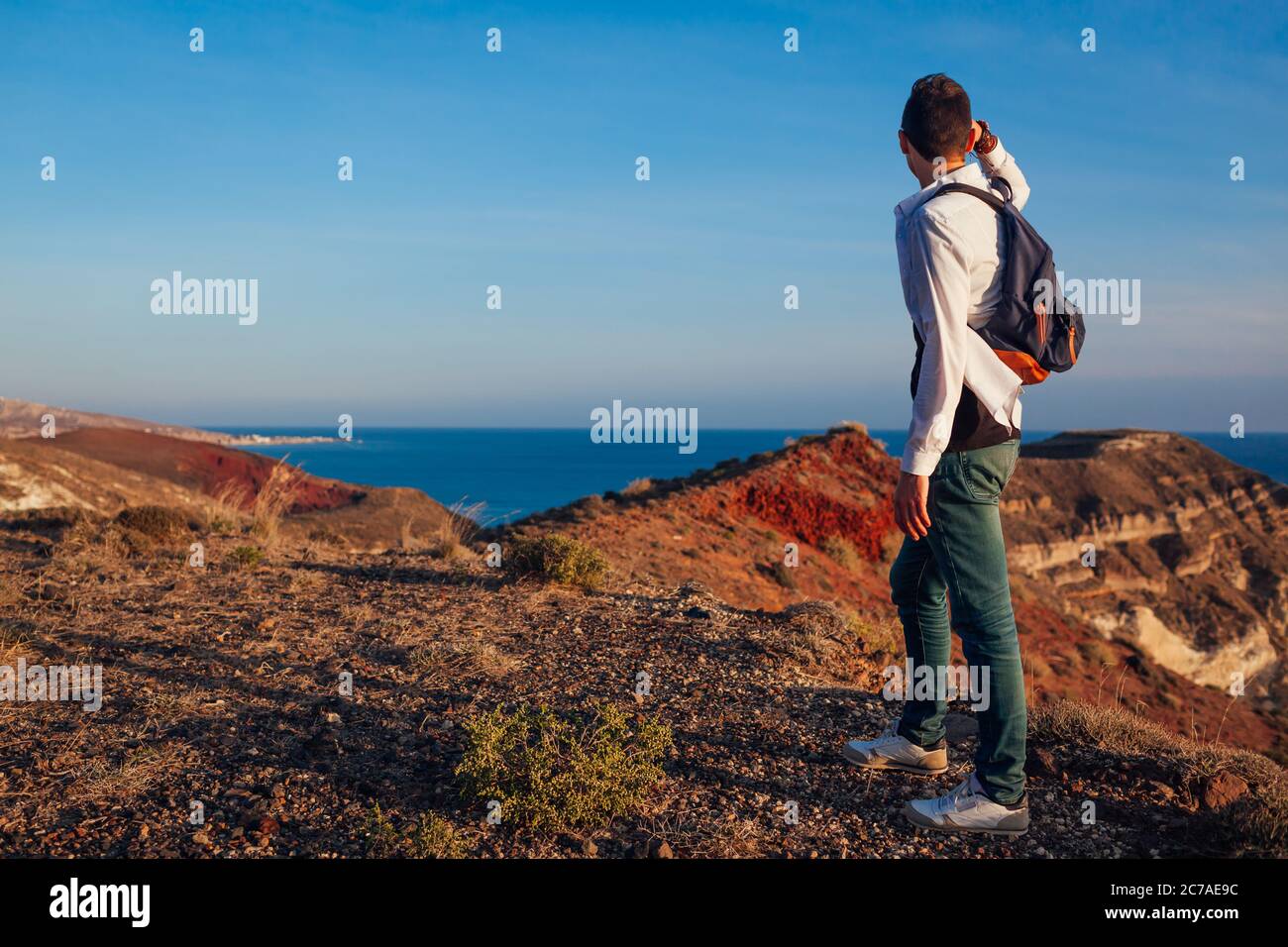Hiker walking by White beach on Santorini island Greece enjoying sea ...