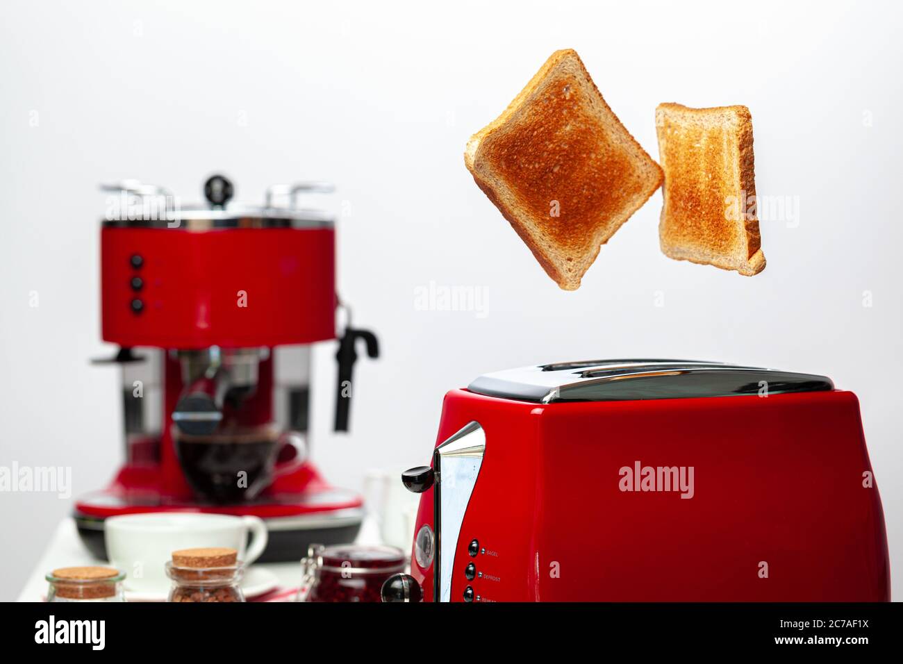 Two toasts jumping out of red toaster against white background Stock ...
