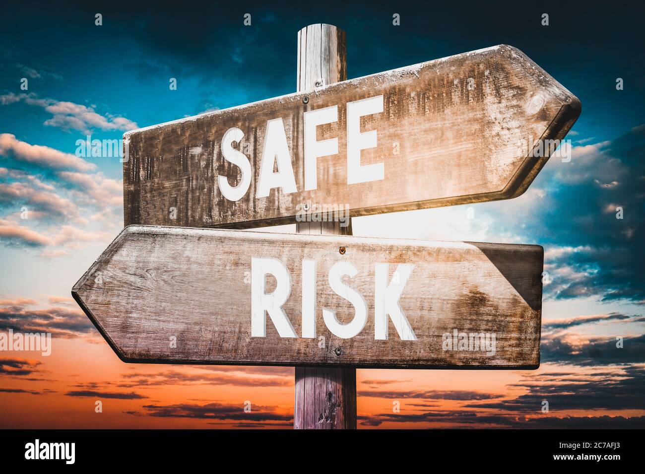 Safe, risk - wooden signpost, roadsign with two arrows Stock Photo - Alamy