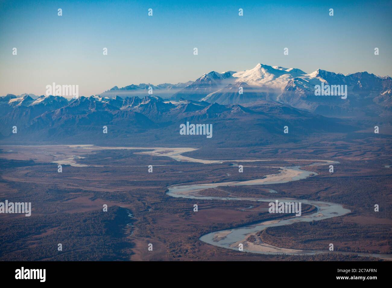 An aerial view of a winding river flowing through the vast Alaskan ...