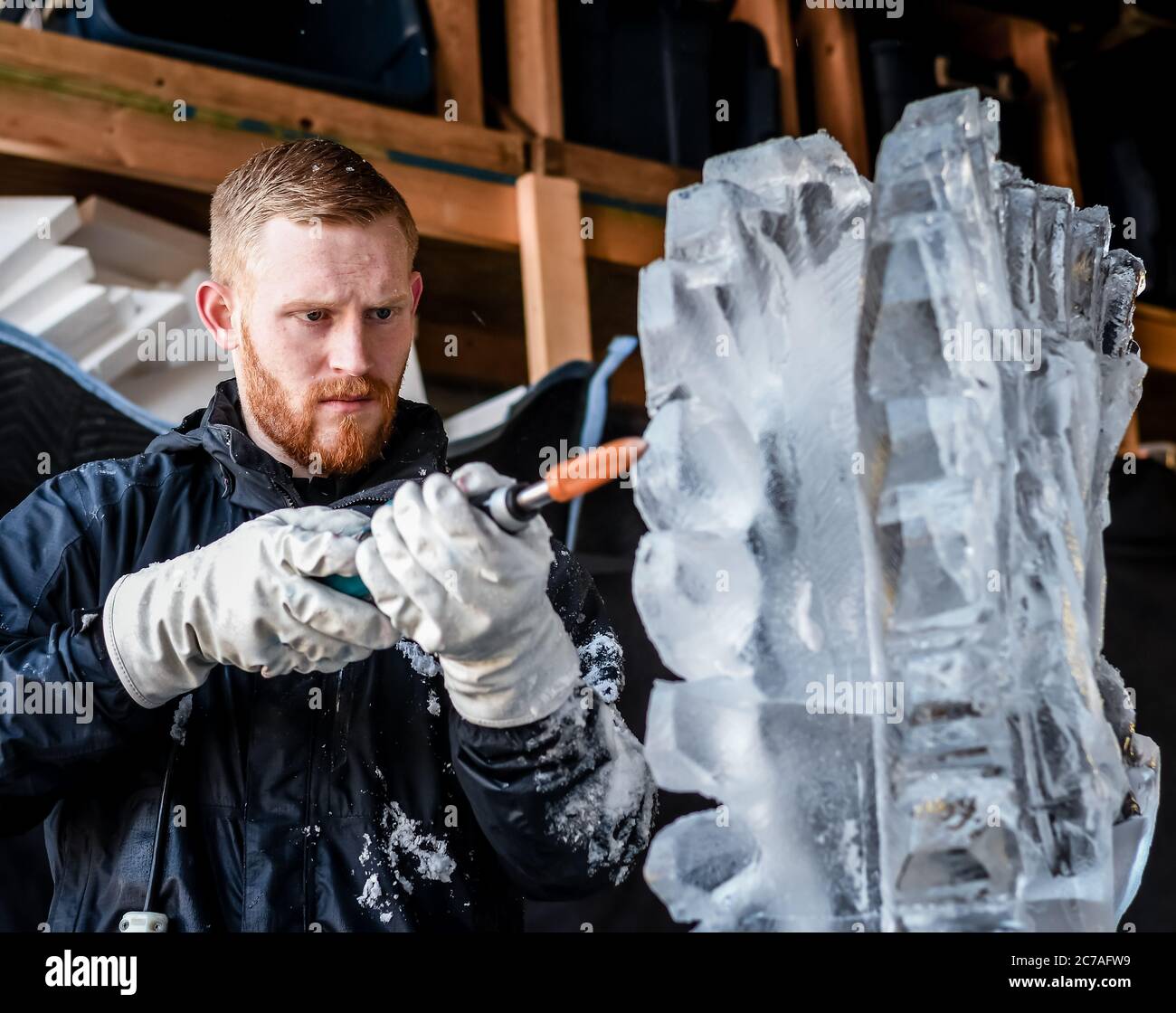 Ice carver sculpting block of ice with electric power dremel Stock ...
