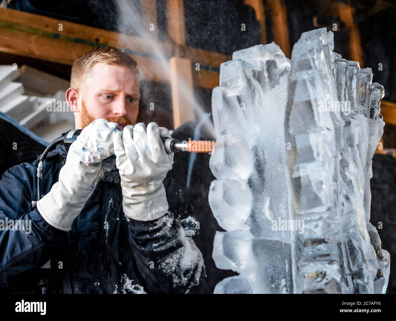 Ice carver sculpting block of ice with electric power dremel Stock ...