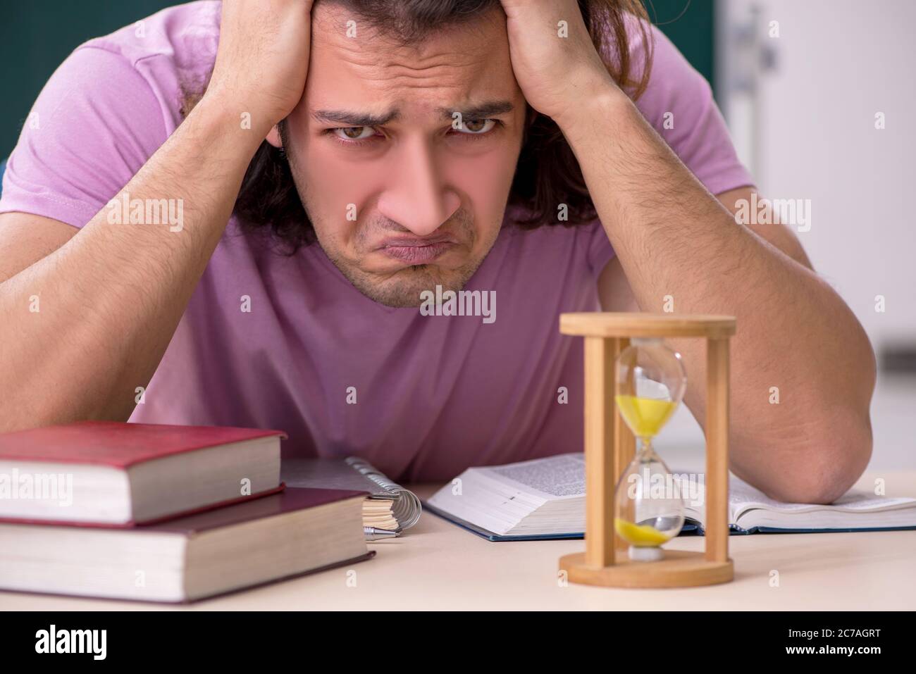 Young student in the classroom at time management concept Stock Photo ...