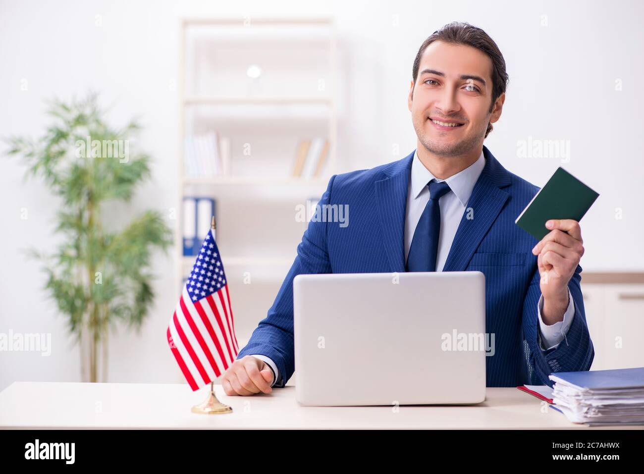 Young man checking passport at the USA embassy Stock Photo - Alamy