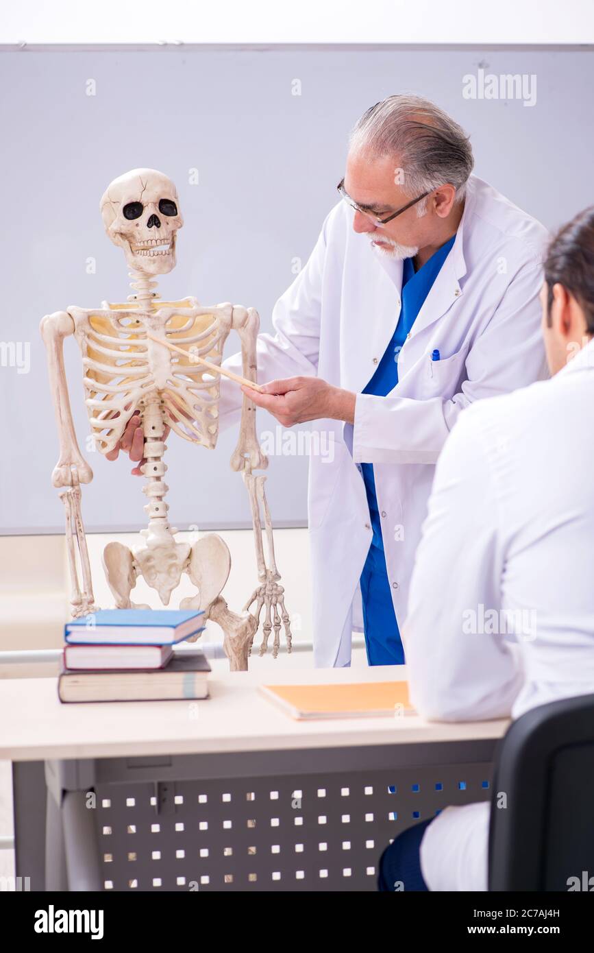 Experienced doctor surgeon teaching young assistant Stock Photo - Alamy