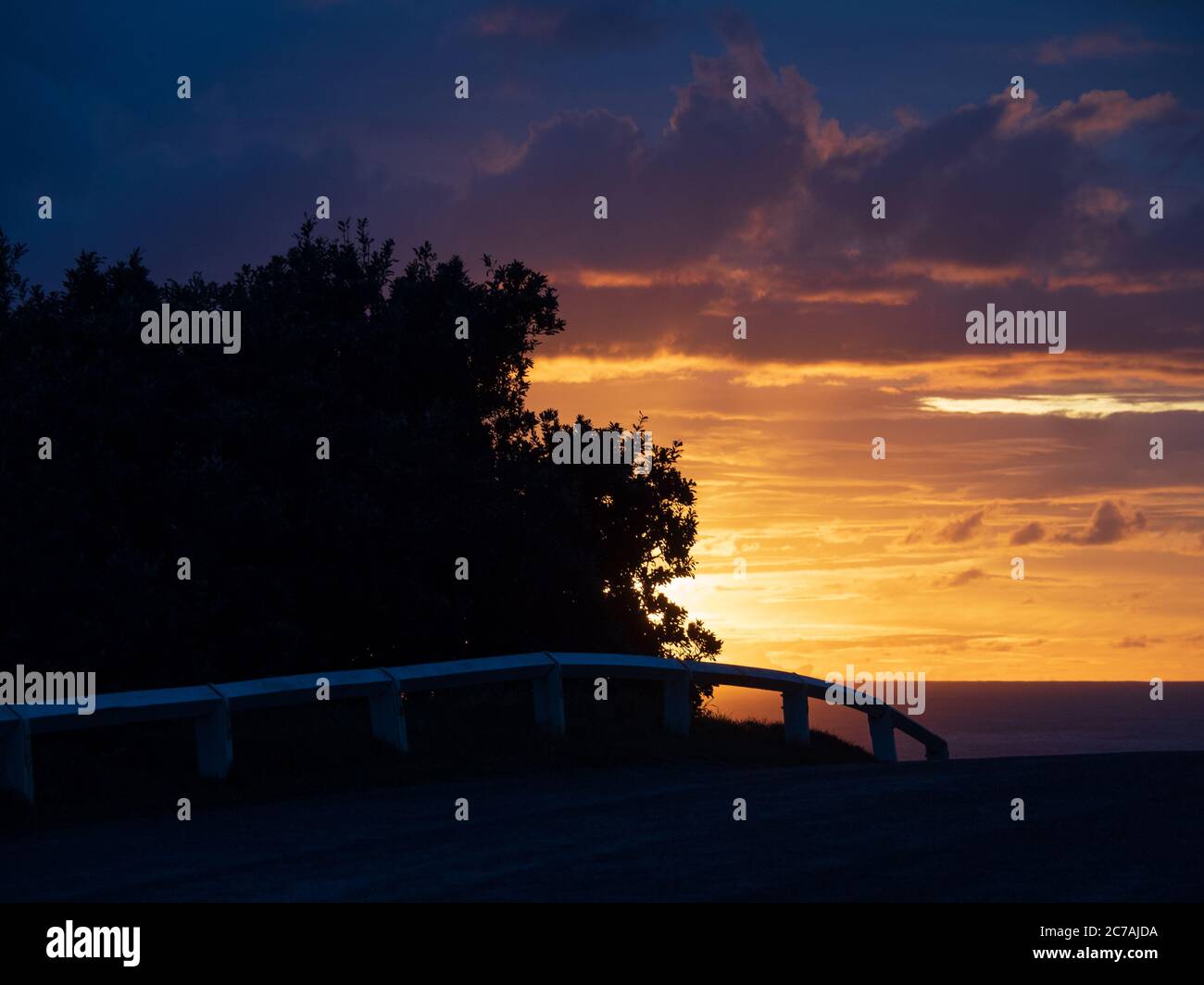 Sunrise over the ocean, glowing yellow sky with daylight streaming out ...