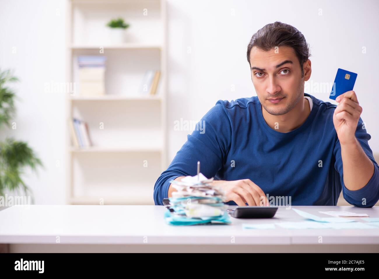 Young man in the budget planning concept Stock Photo - Alamy