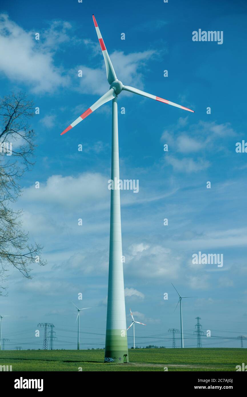 Alternative energy source power generating wind turbines over green field and blue sky Stock ...