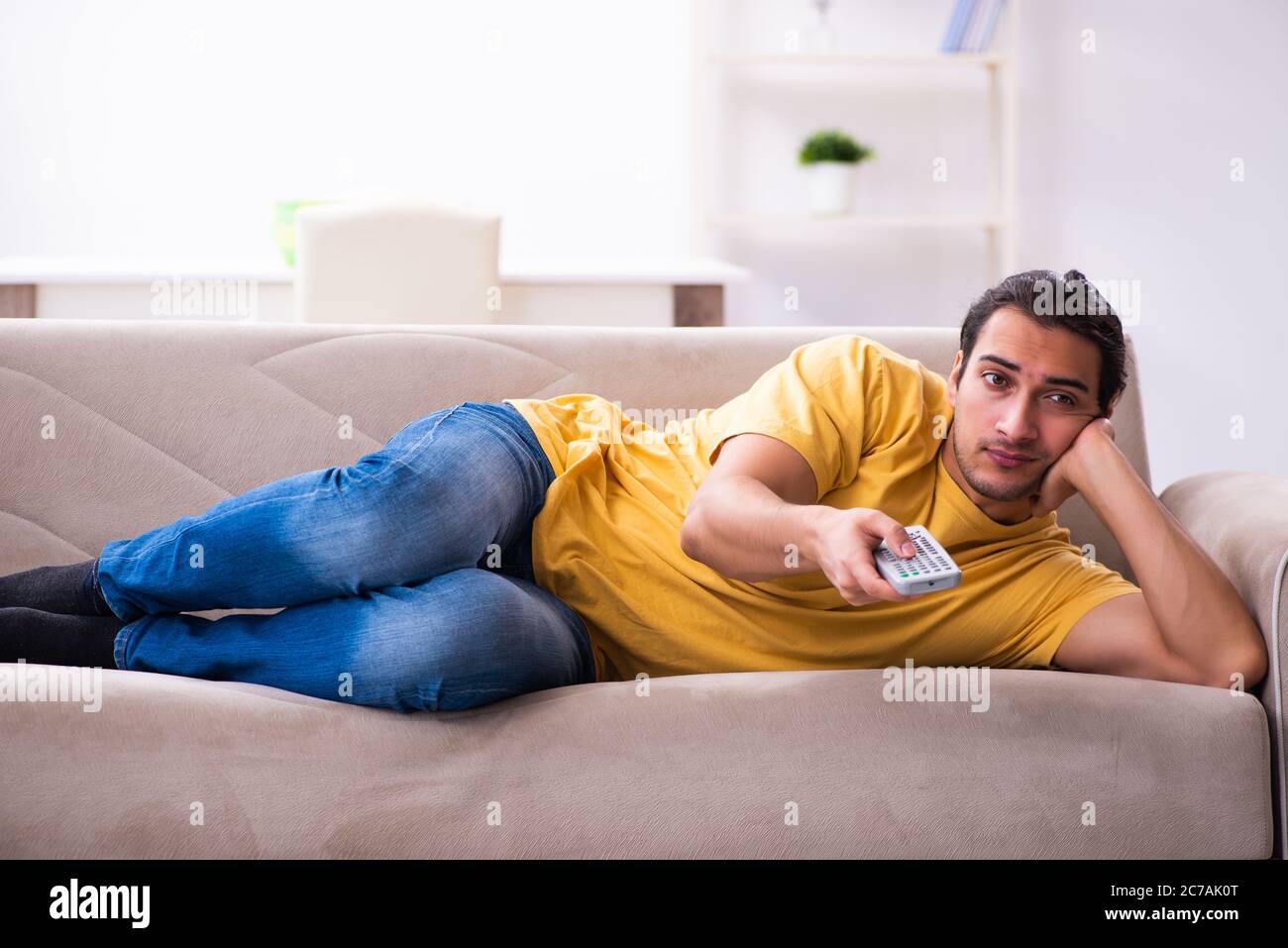 Young man watching tv at the home Stock Photo - Alamy
