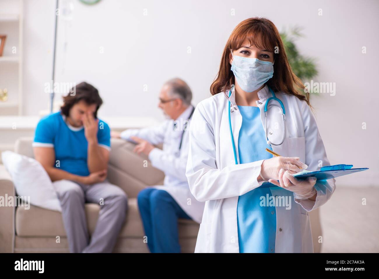 Two doctors visiting sick man at home Stock Photo - Alamy