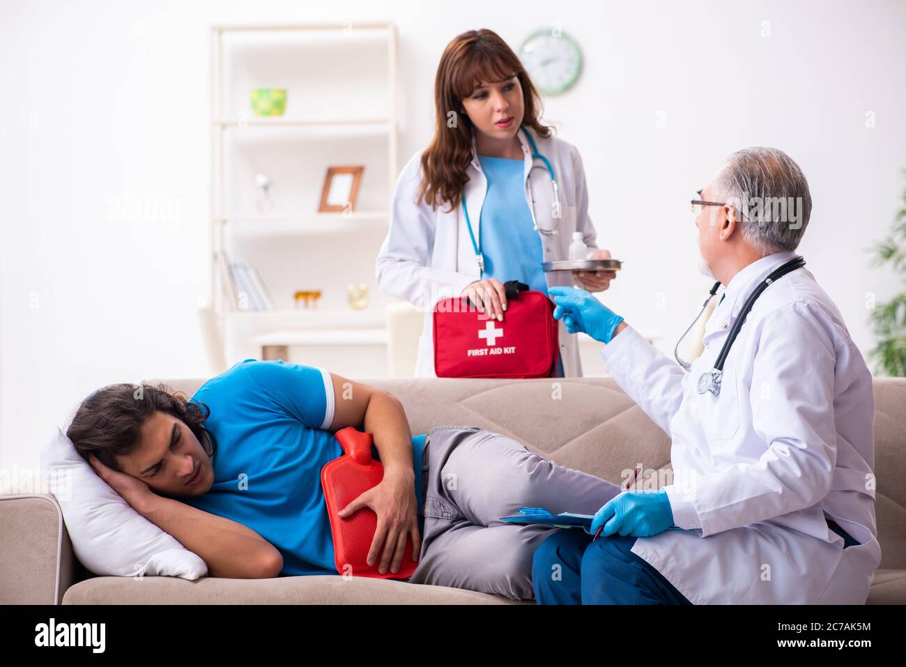Two doctors visiting sick man at home Stock Photo - Alamy