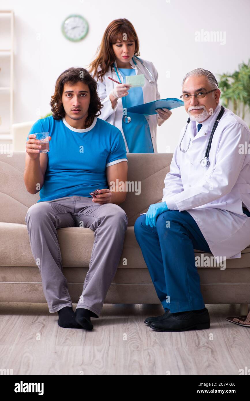 Two doctors visiting sick man at home Stock Photo - Alamy