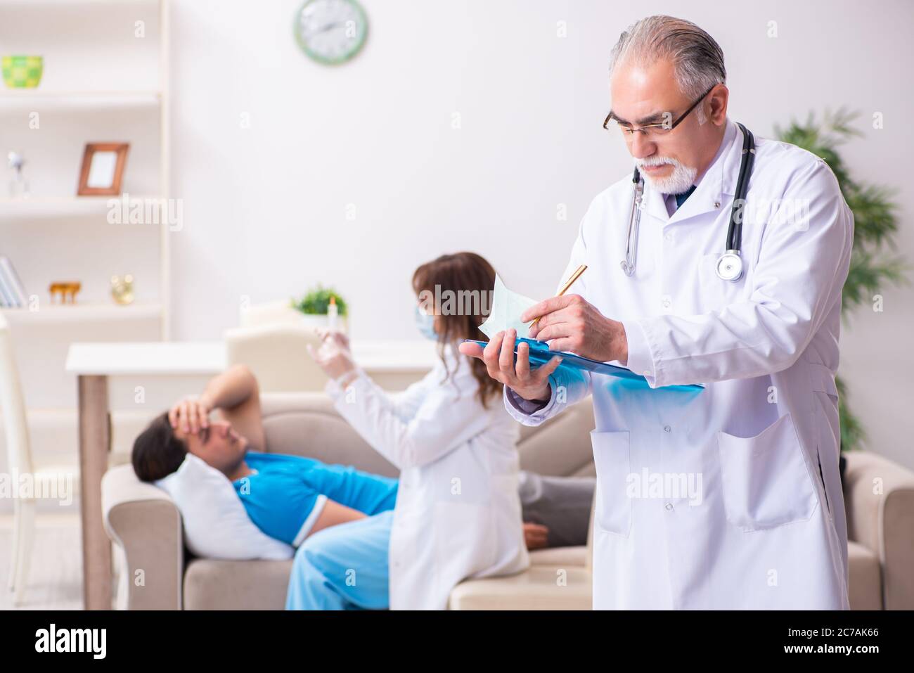 Two doctors visiting sick man at home Stock Photo - Alamy