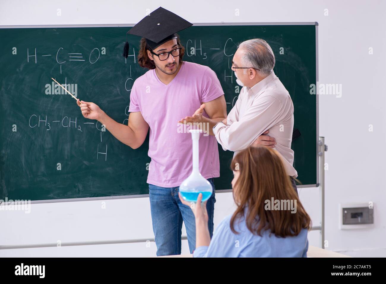 Old teacher and two students in the classroom Stock Photo - Alamy
