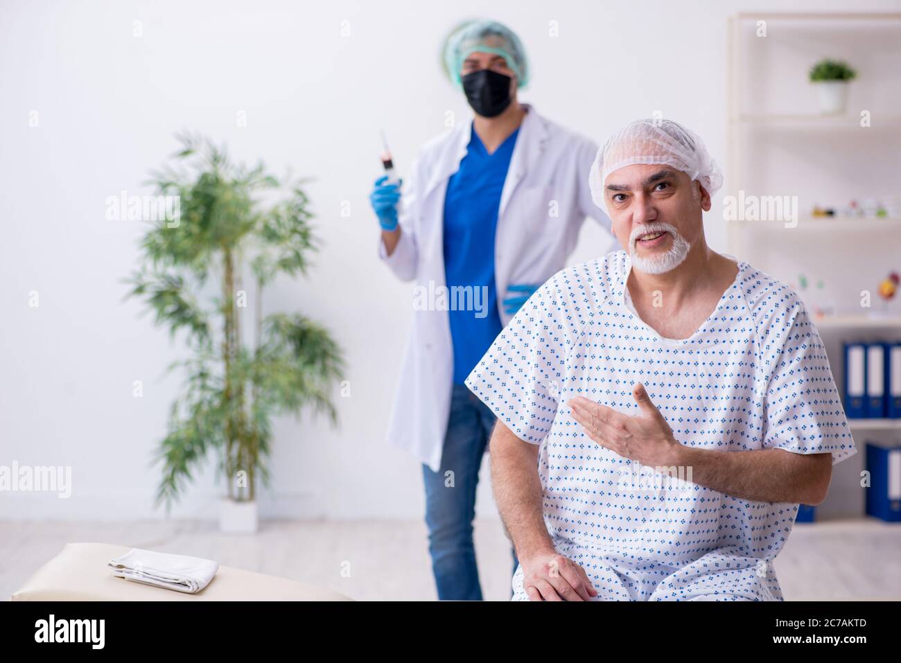 Old man visiting young intern doctor Stock Photo - Alamy