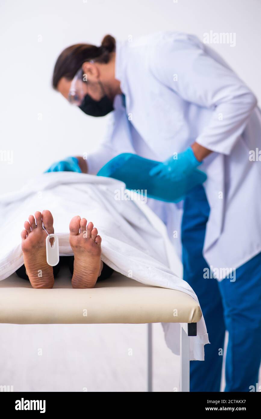 Police coroner examining dead body in morgue Stock Photo - Alamy