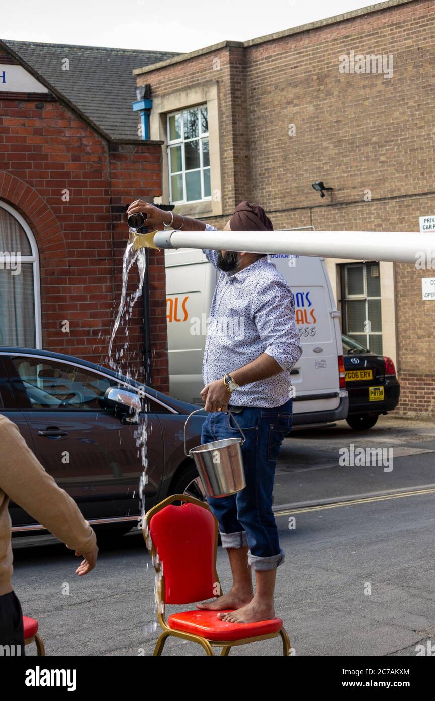 The Sikh cleaning a mast with the traditional Gurdwara flag Stock Photo ...