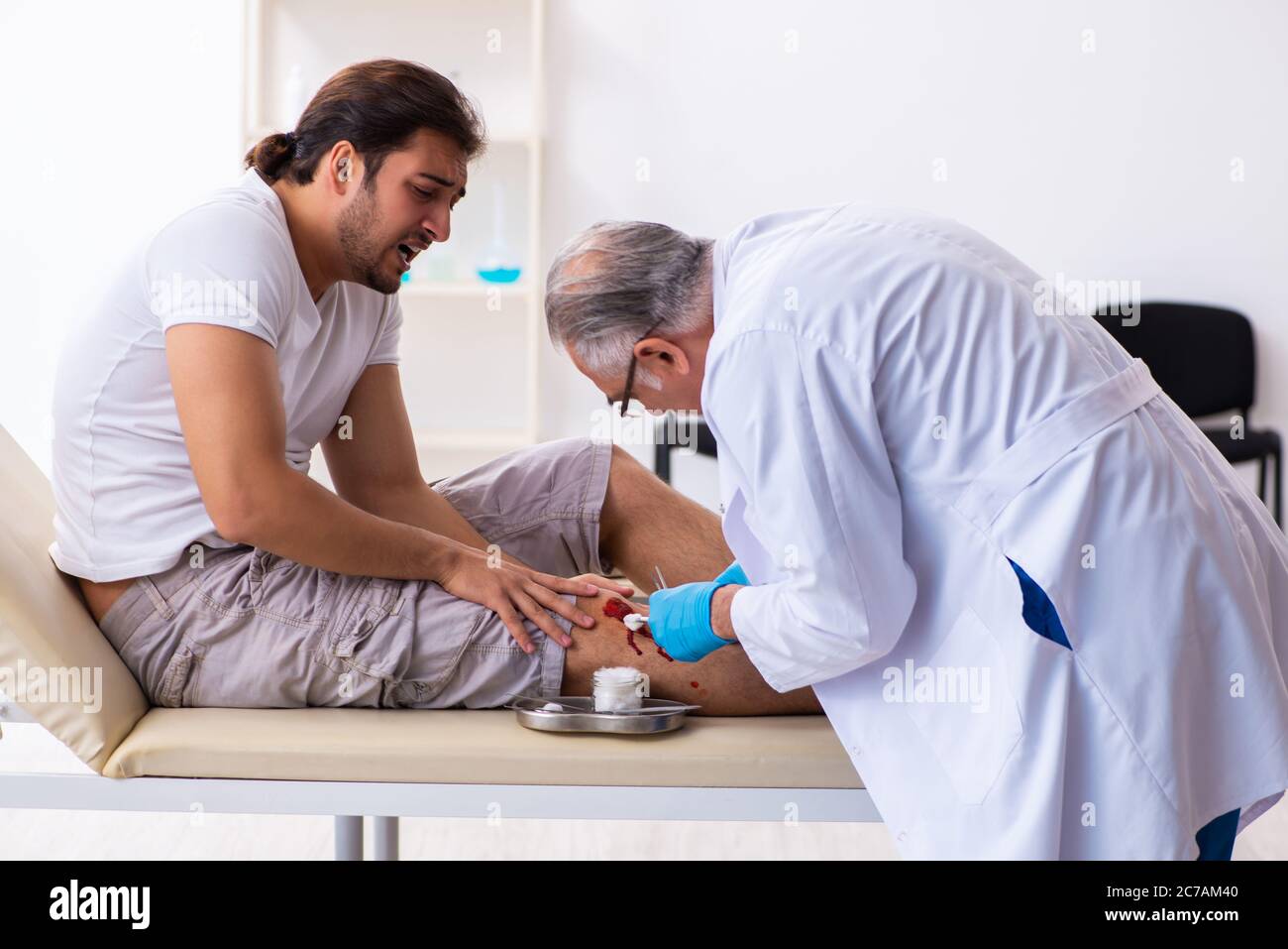 Leg injured man visiting doctor in first aid concept Stock Photo - Alamy