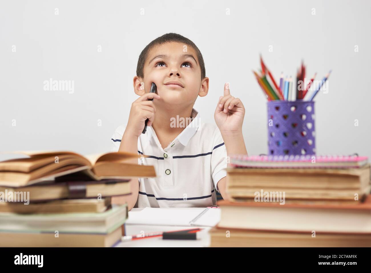 Thoughtful schoolboy having idea, raising finger. I know it. Primary ...