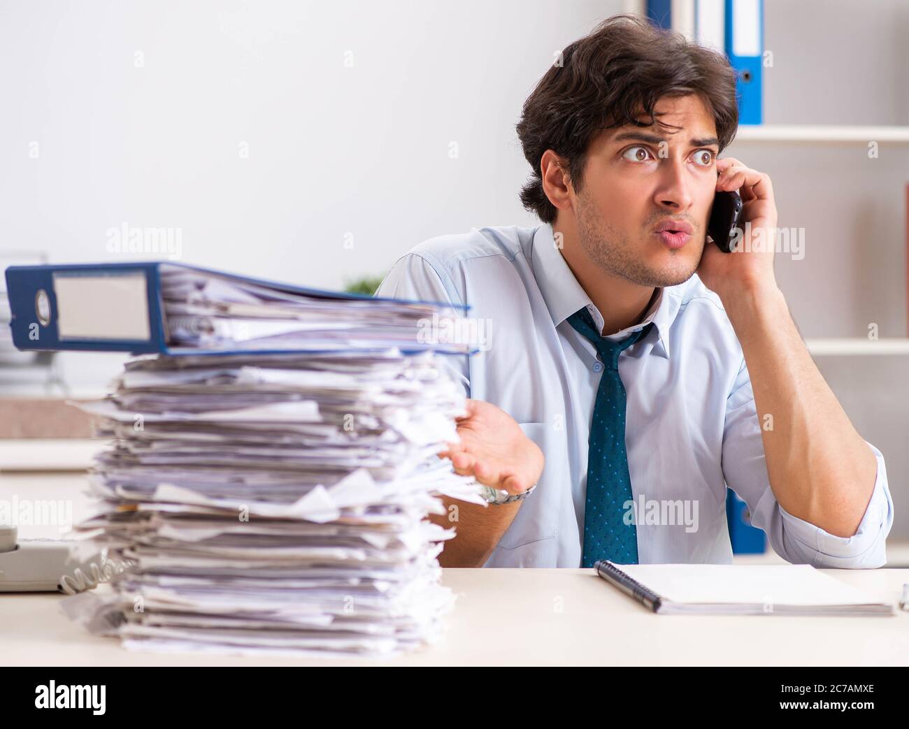 The overloaded busy employee with too much work and paperwork Stock ...