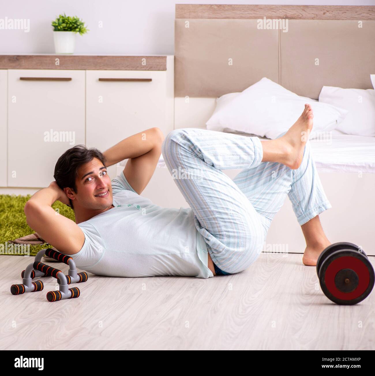 The young man doing morning routine in bedroom Stock Photo - Alamy