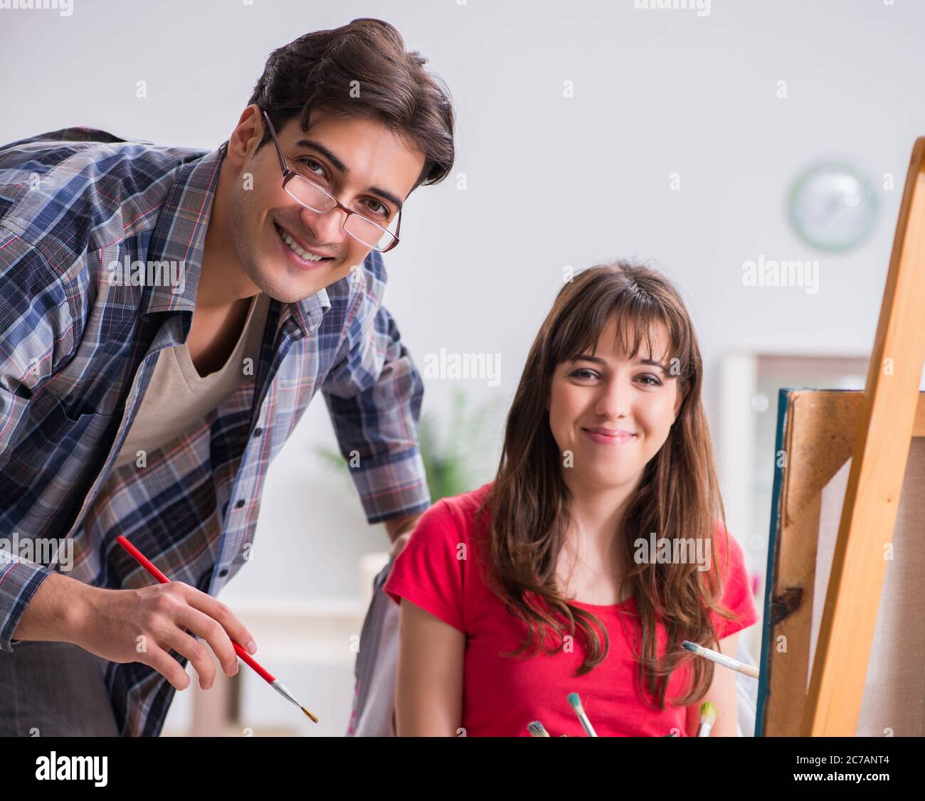 The artist coaching student in painting class in studio Stock Photo - Alamy