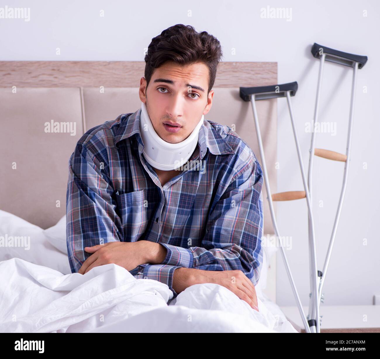The injured man in bed at home with crutches Stock Photo - Alamy