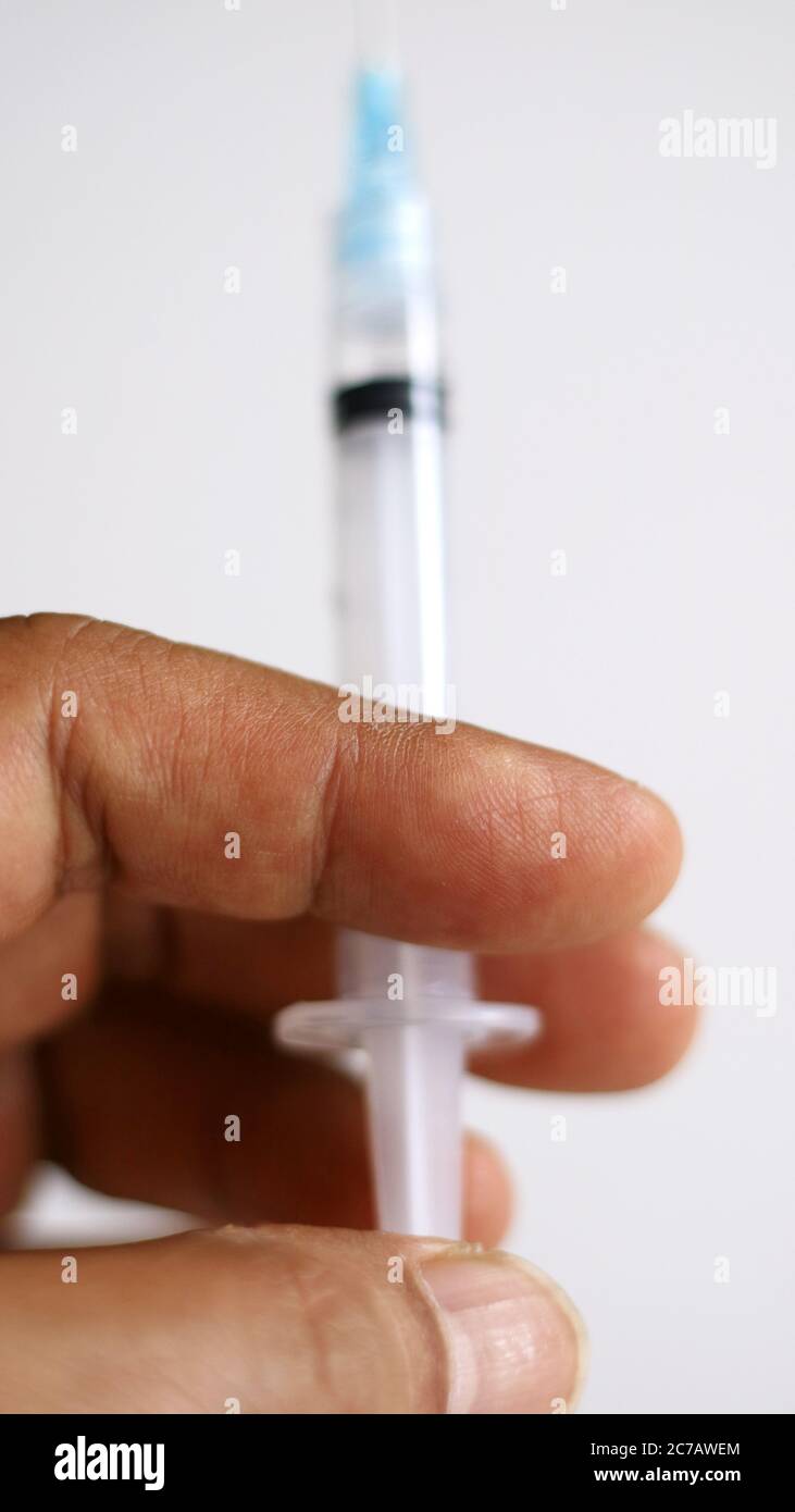 Syringe in a hand , ready for injection Stock Photo - Alamy