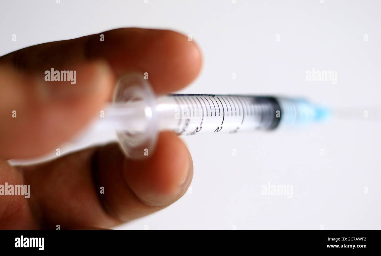 Syringe in a hand , ready for injection Stock Photo - Alamy