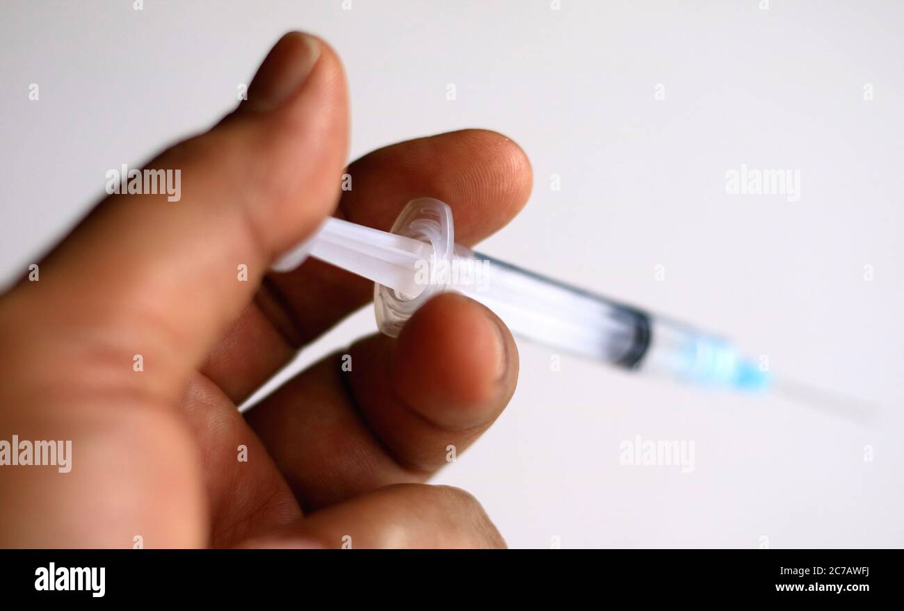 Syringe in a hand , ready for injection Stock Photo - Alamy