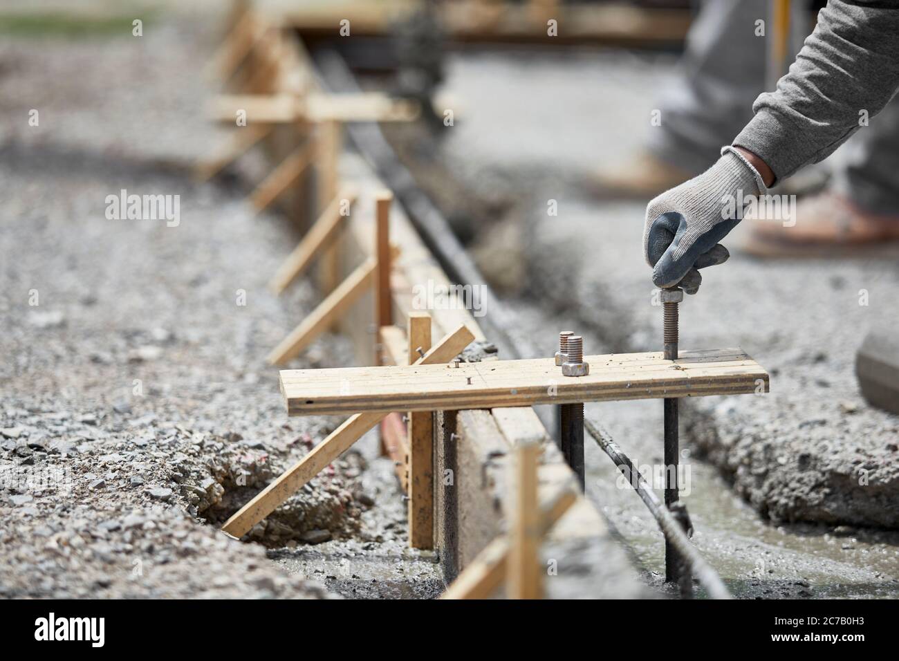 Construction worker placing the steel anchor rod into the wet cement of ...