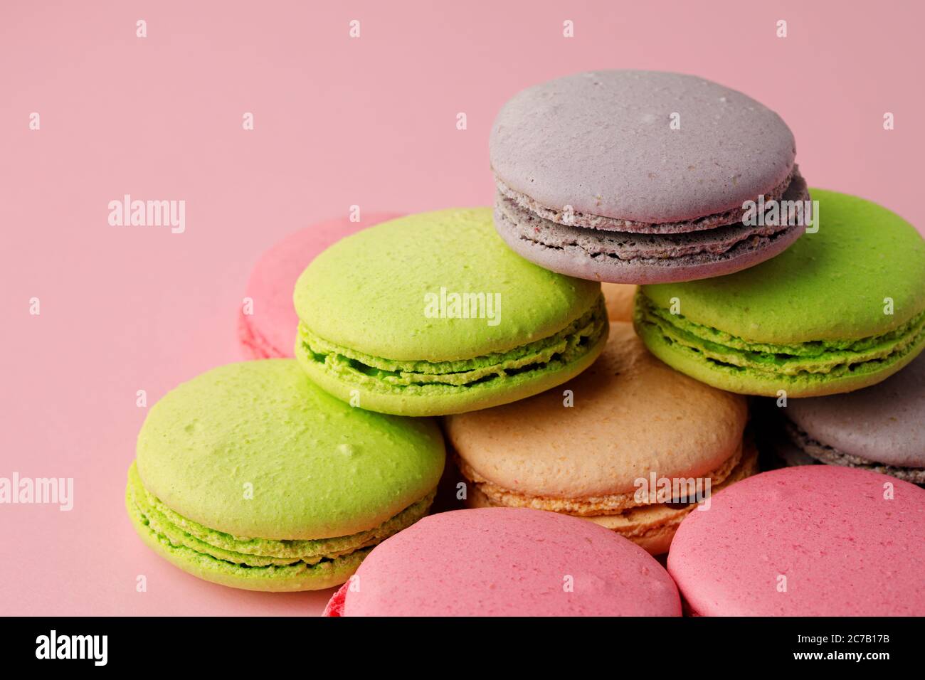 Pile of colorful macaroon cookies on pink background Stock Photo - Alamy