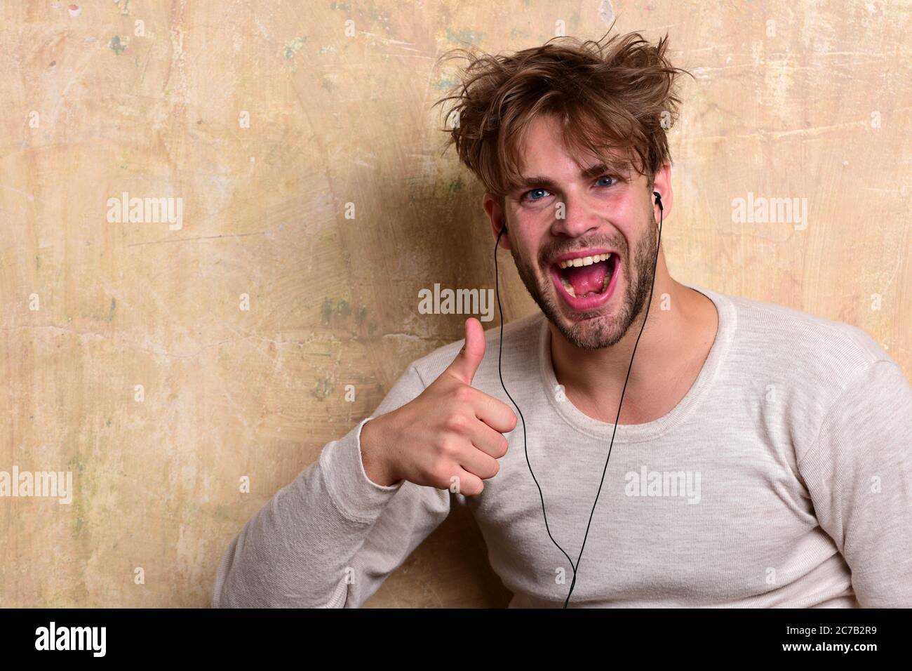 Man with cheerful face shows thumbs up. Guy with bristle wears ...