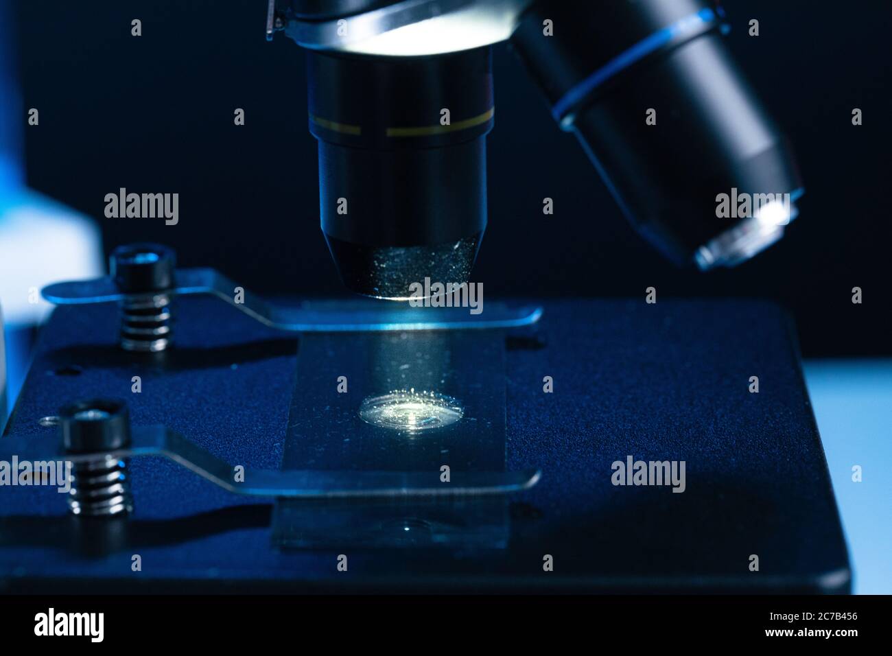 Microscope with lenses close up against dark background Stock Photo - Alamy