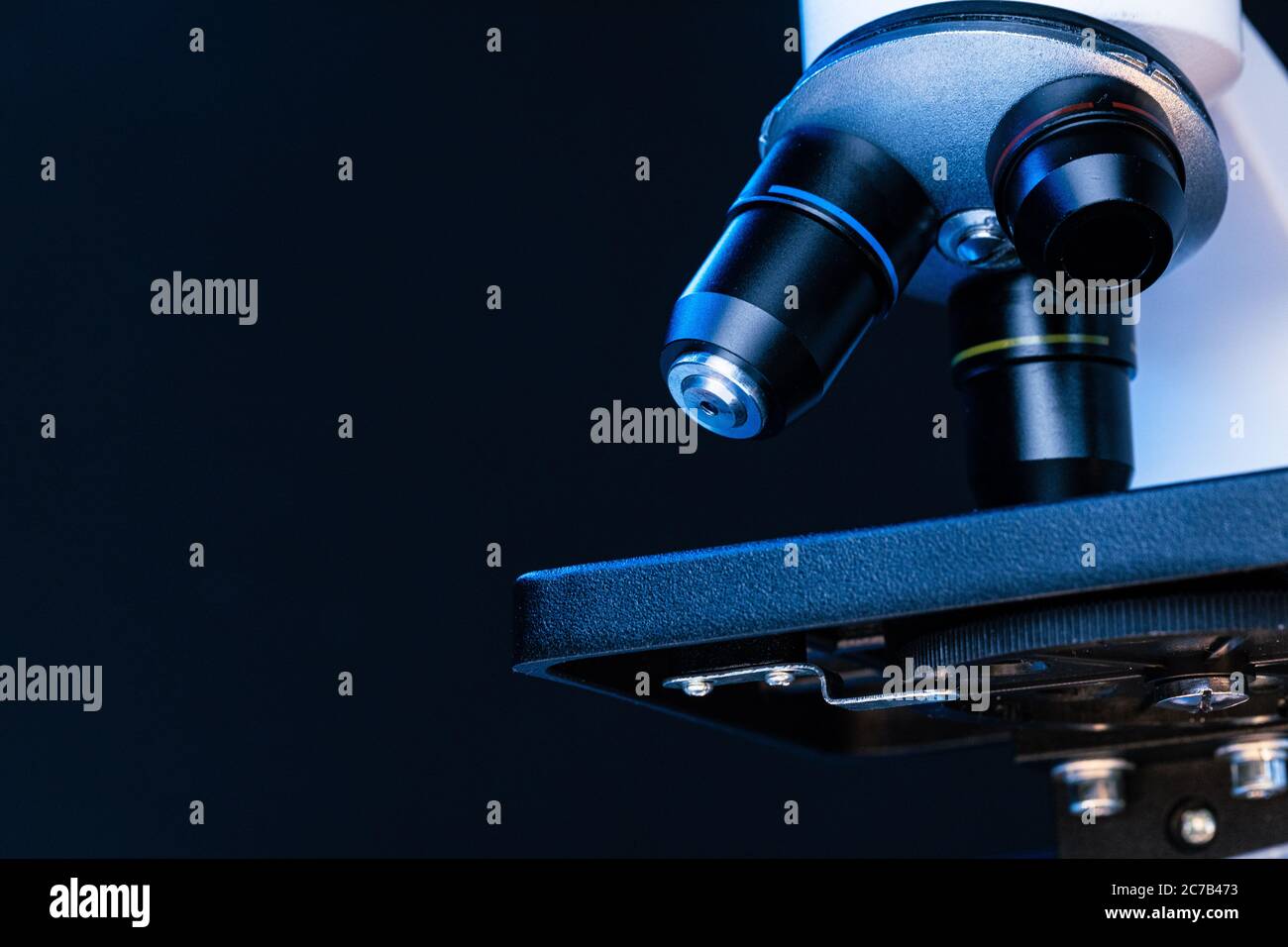 Microscope with lenses close up against dark background Stock Photo - Alamy