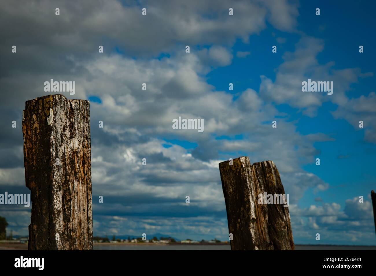 Two Old pier posts below cloudy sky Stock Photo - Alamy