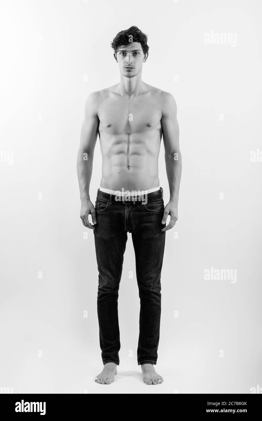 Full body shot of young handsome man standing shirtless Stock Photo - Alamy