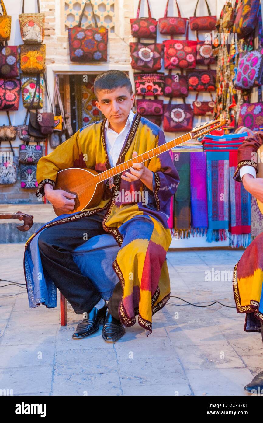 A musician is playing a lute (string instrument) at the Nodir Devon ...