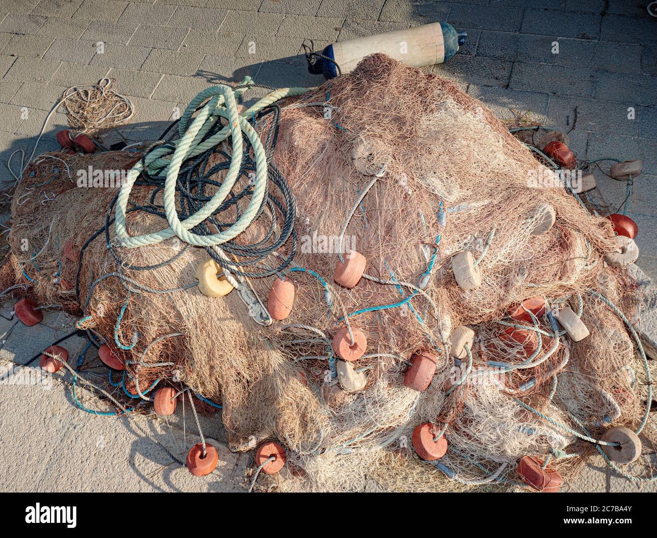 Commercial yellow and gray color fishing nets in port on the stony ...
