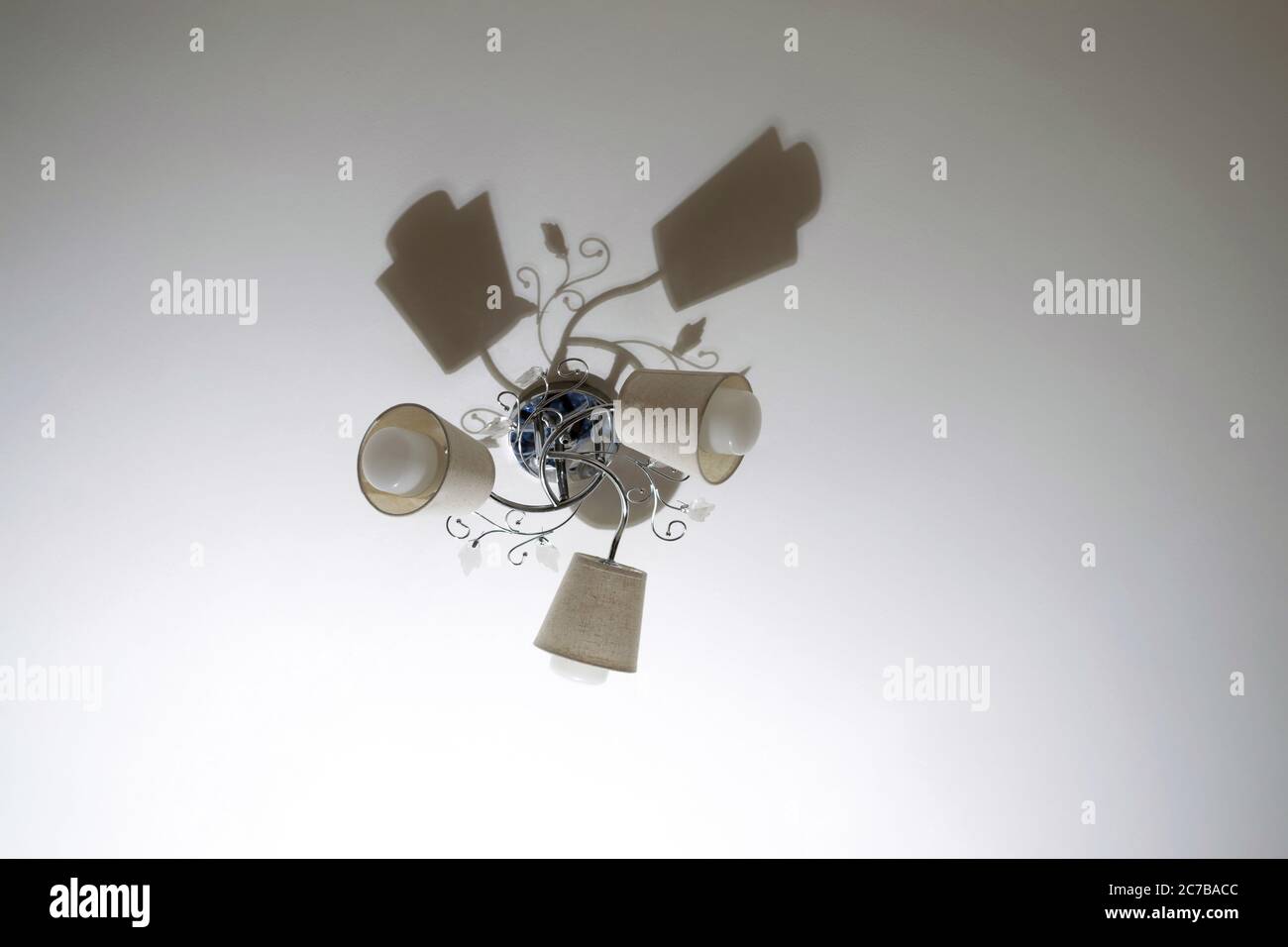 Beautiful shadow from the chandelier on the ceiling in the room, three ...