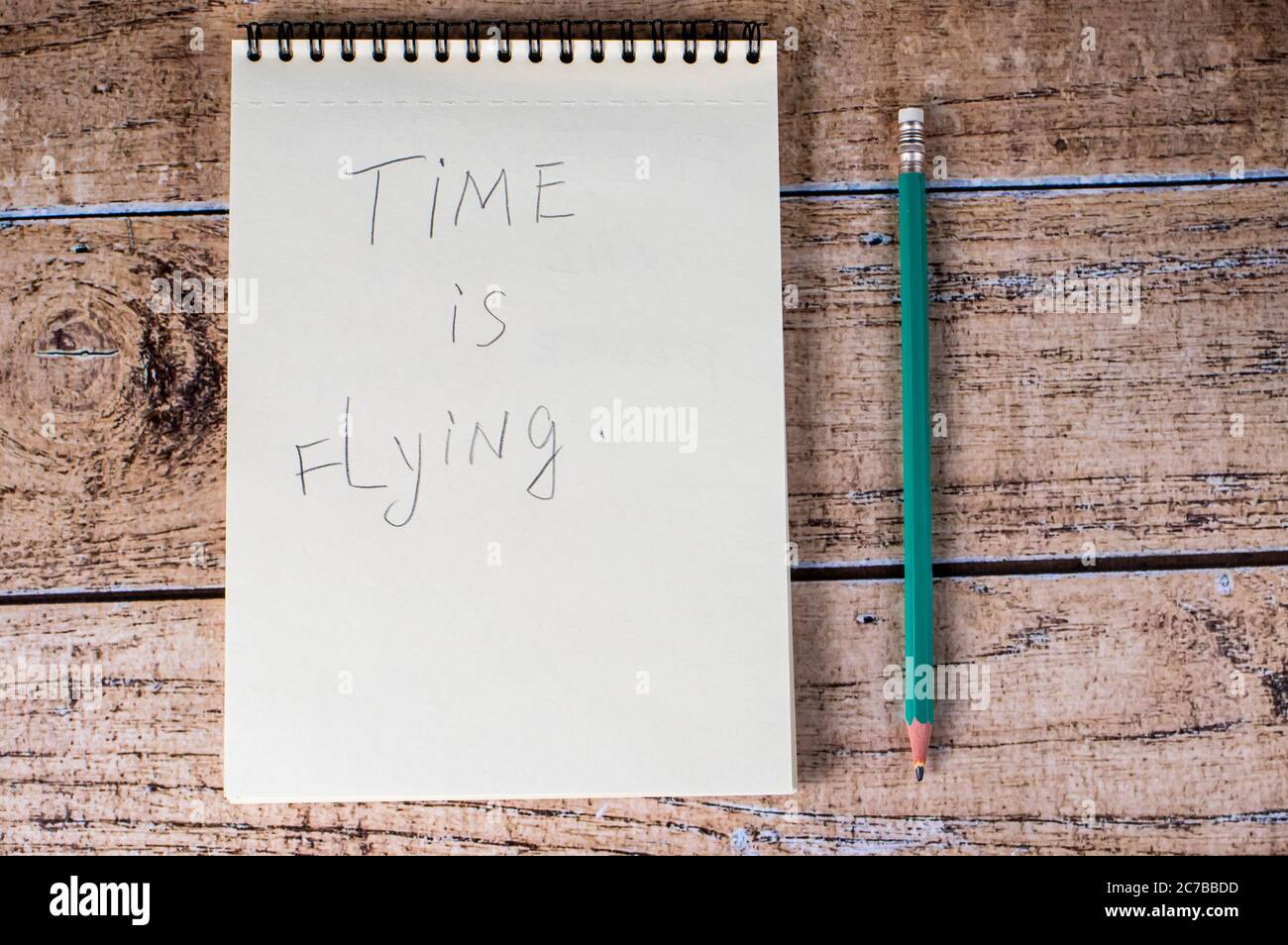 Notebook and green pencil, inscription Time is flying. Motivational ...