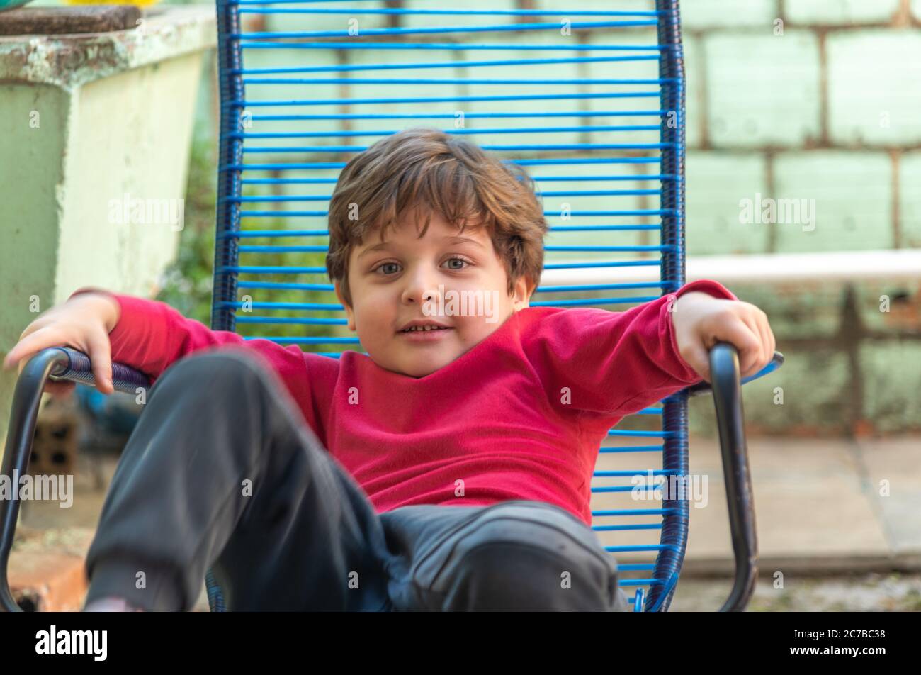 Caucasian child. Brazilian boy. Kid in the rocking chair. Children's ...