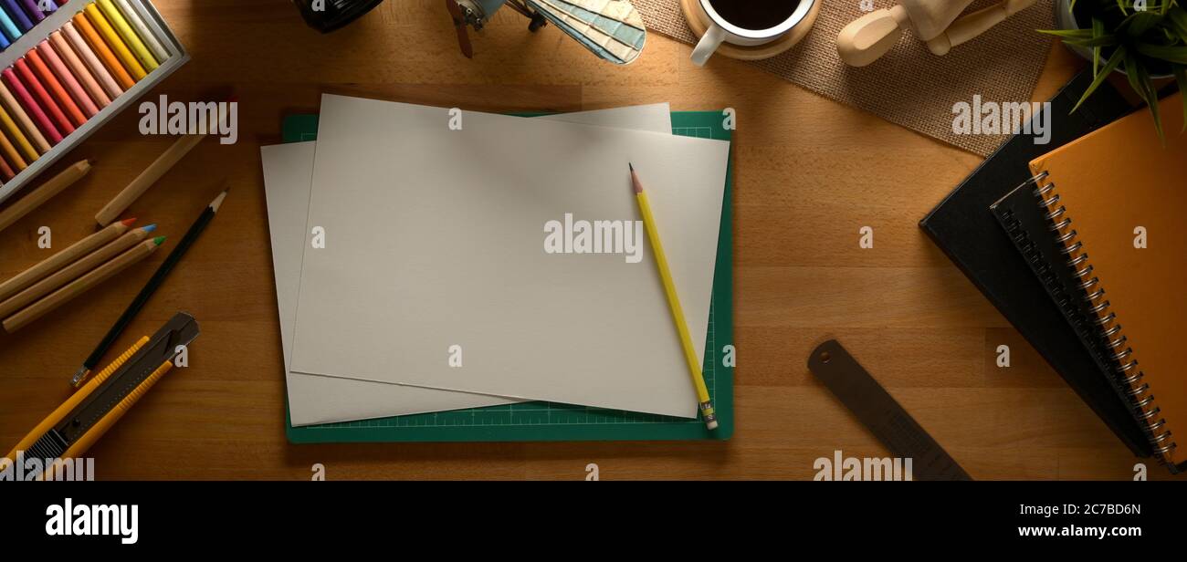 Top view of wooden worktable with sketch paper, painting tools ...