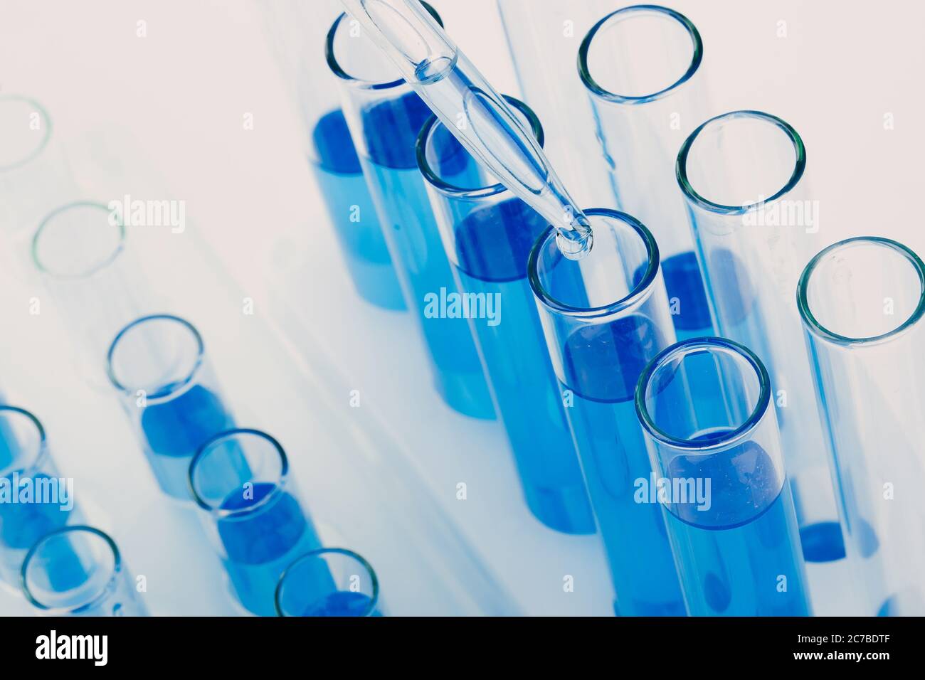 Laboratory glassware with a dropper dripping liquid into a test tube ...