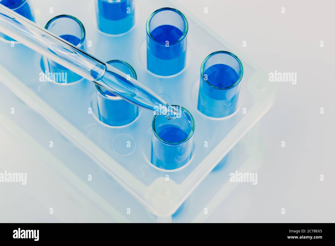 Laboratory glassware with a dropper dripping liquid into a test tube ...