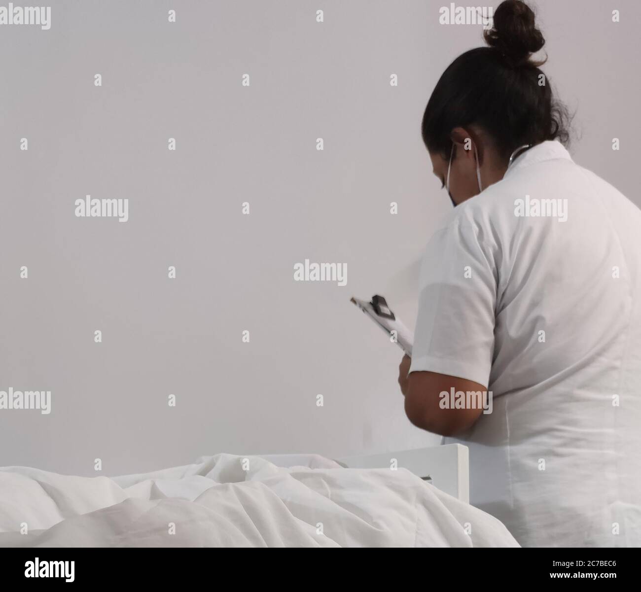 Nurse making notes in medical records. Hospital bed. Health ...