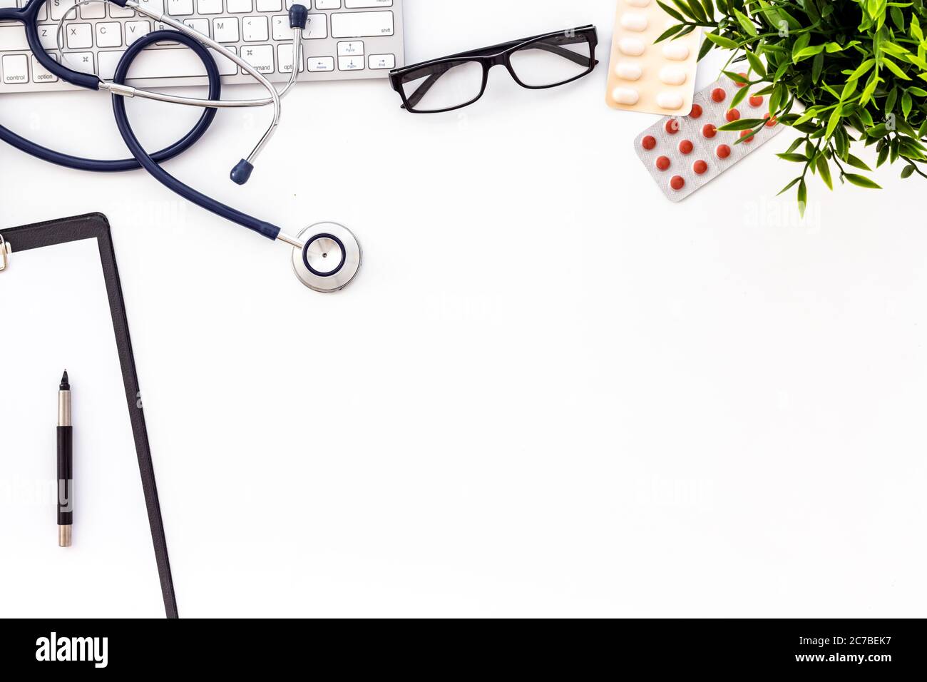 Doctor desk with pills, tablet, stethoscope. White table top-down space ...