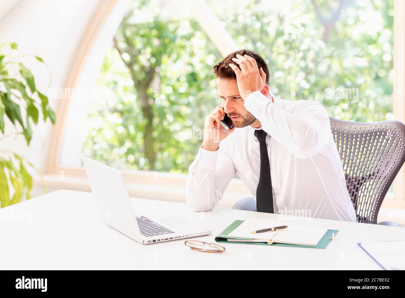 Shot of confused businessman wearing shirt and tie while sitting at ...