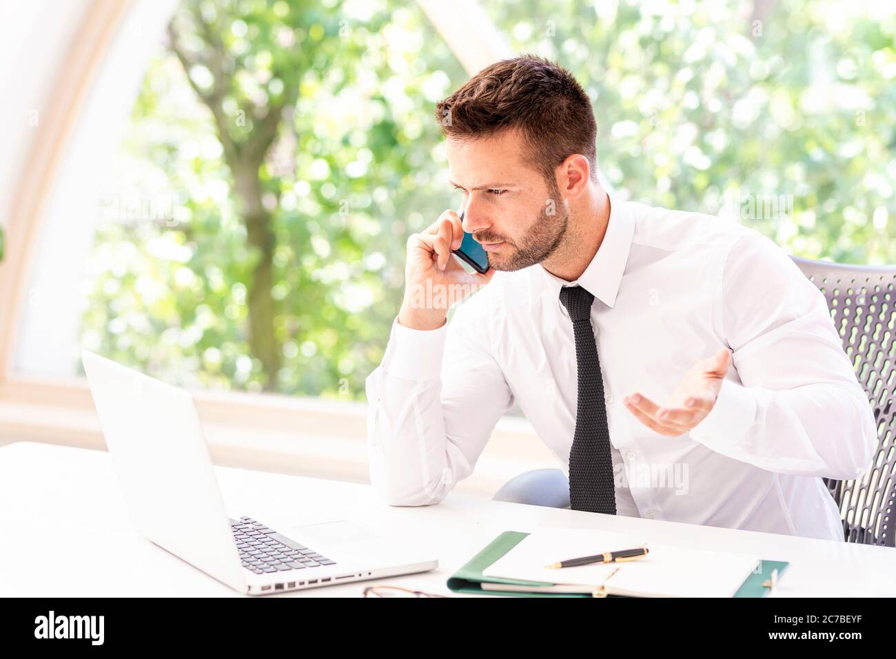 Shot of confused businessman wearing shirt and tie while sitting at ...